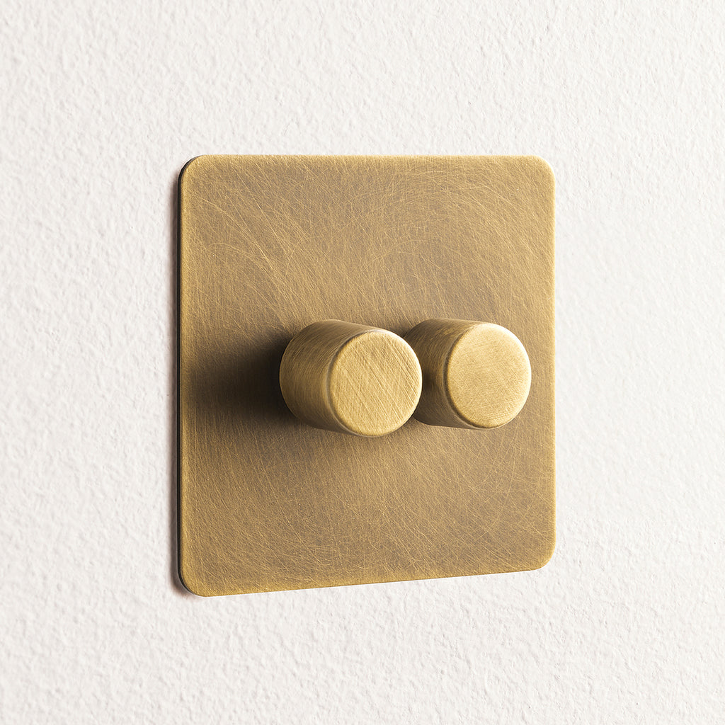Lucian two gang dimmer switch in aged brass