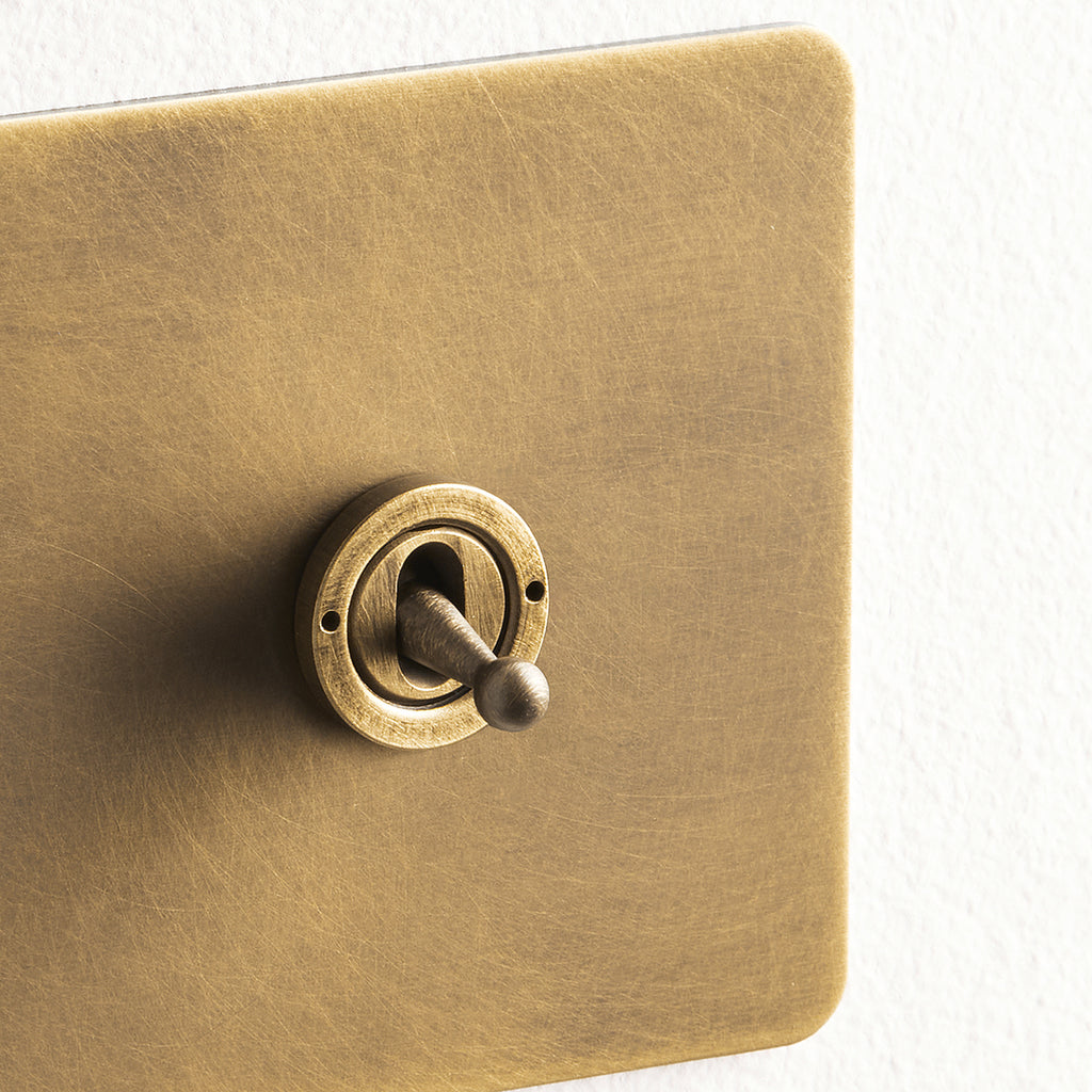 Lucian one gang intermediate toggle switch in aged brass