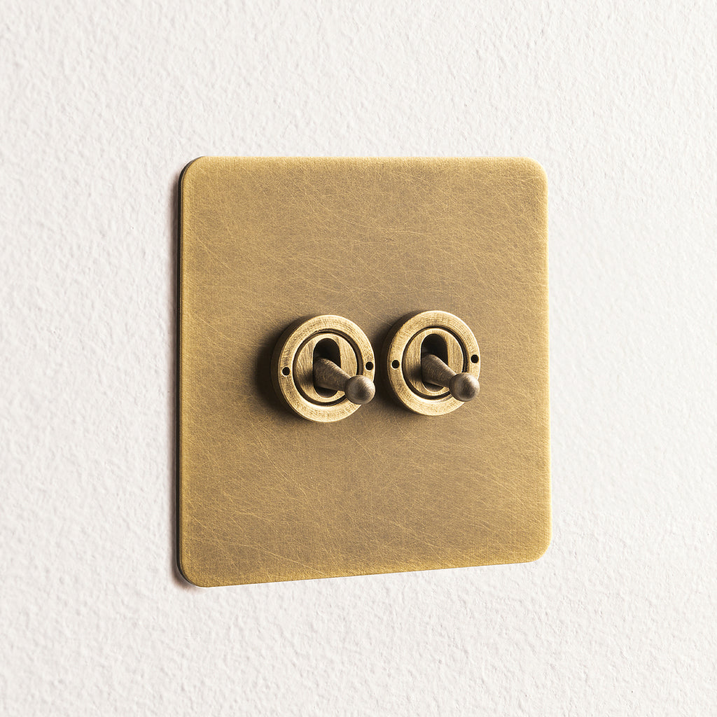 Lucian two gang intermediate toggle switch in aged brass