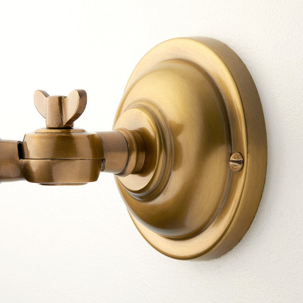 Double jointed wall fitting in antiqued brass
